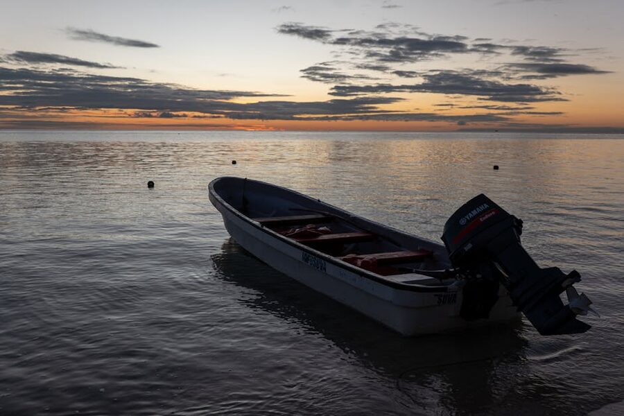 A boat anchored at sunset near a Fijian island