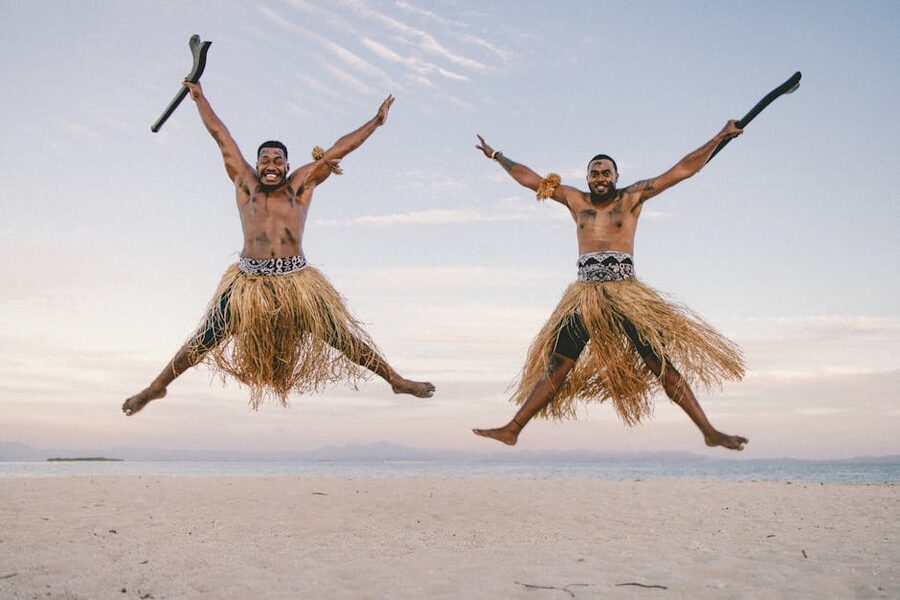 Fijian men in traditional skirts on a beach