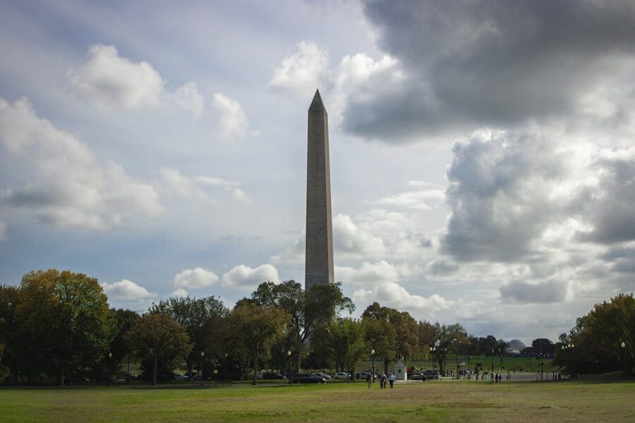 Washington Monument under dramatic sky with people in foreground