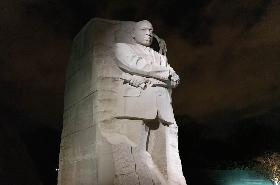 Martin Luther King Jr Memorial statue lit against the night sky