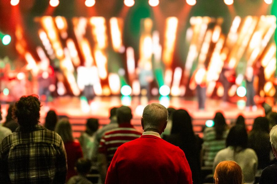 Crowd watching colorful stage performance in theater