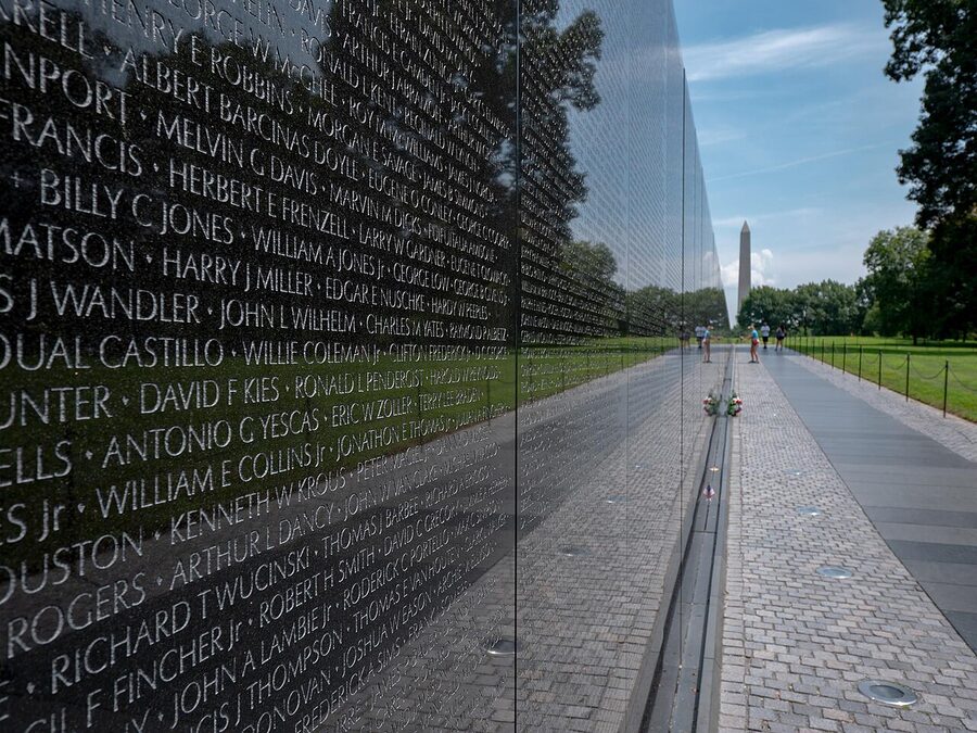 Vietnam Veterans Memorial Wall with the Washington Monument visible beyond