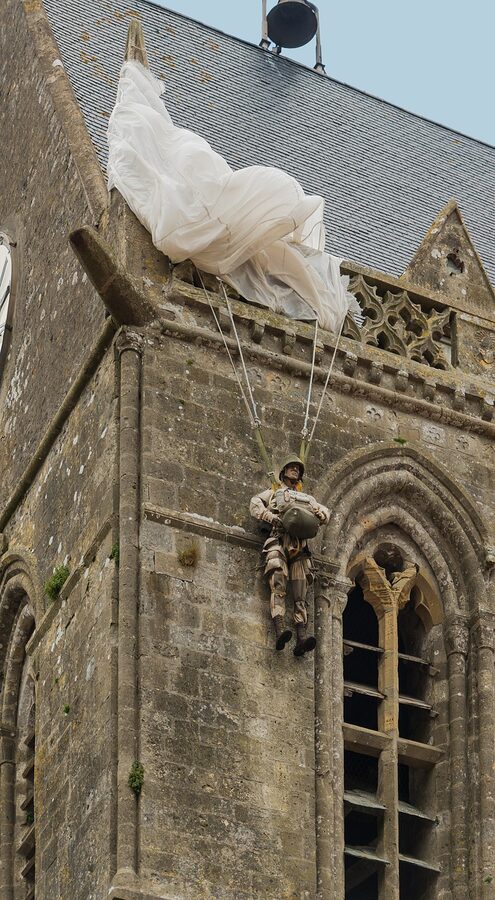 Effigy of paratrooper John Steele hanging from the bell tower of Sainte-Mere-Eglise church