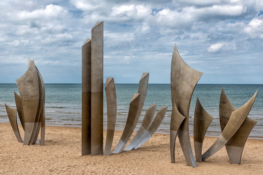 Les Braves Memorial sculpture standing on Omaha Beach in the surf, Normandy