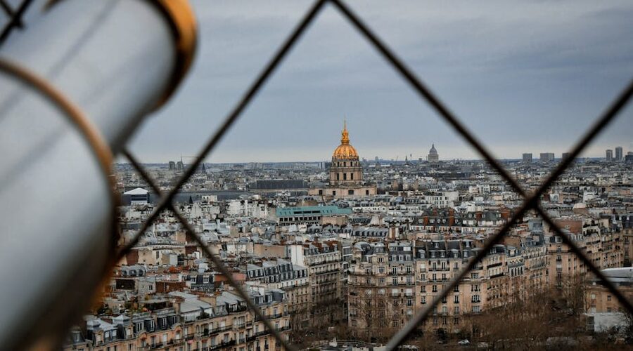 Paris skyline seen through the Eiffel Tower iron lattice