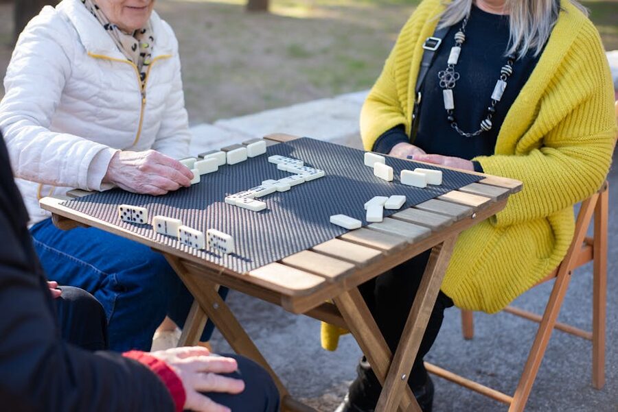 Elderly men playing dominoes at an outdoor table