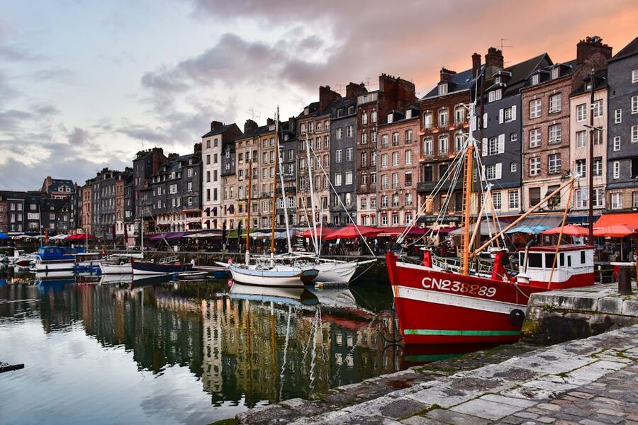 Honfleur harbor with colorful buildings and boats at sunset