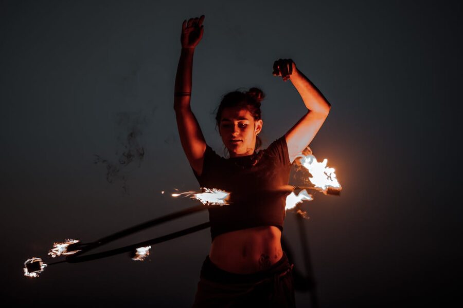 Woman performing a captivating fire dance with hoops at night