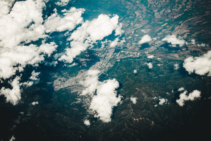 Aerial view of clouds floating above diverse landscape