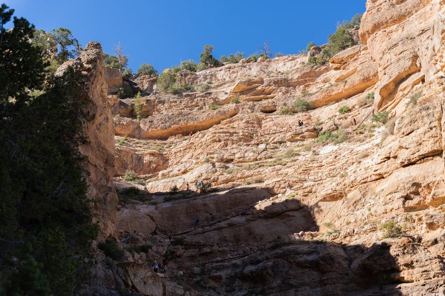 Hikers navigating steep Grand Canyon cliffs on a trail