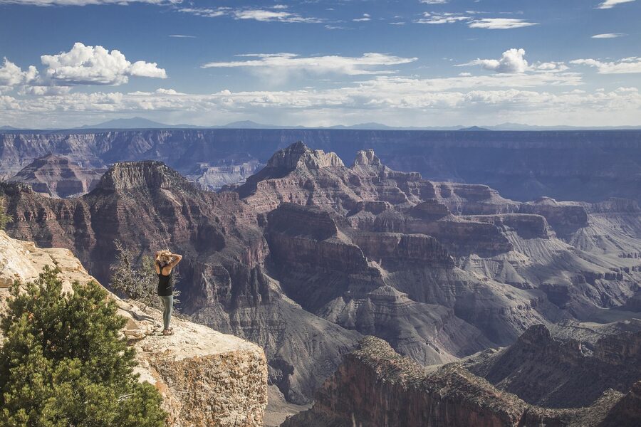 Woman standing at Grand Canyon viewpoint taking in the view