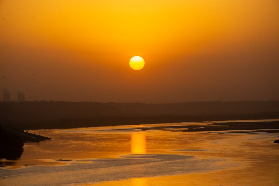 Golden sunset reflecting over a calm river with warm colors