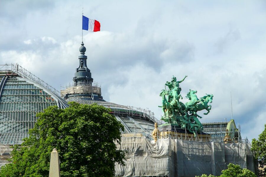 Grand Palais Paris quadriga sculptures and dome silhouetted against cloudy sky