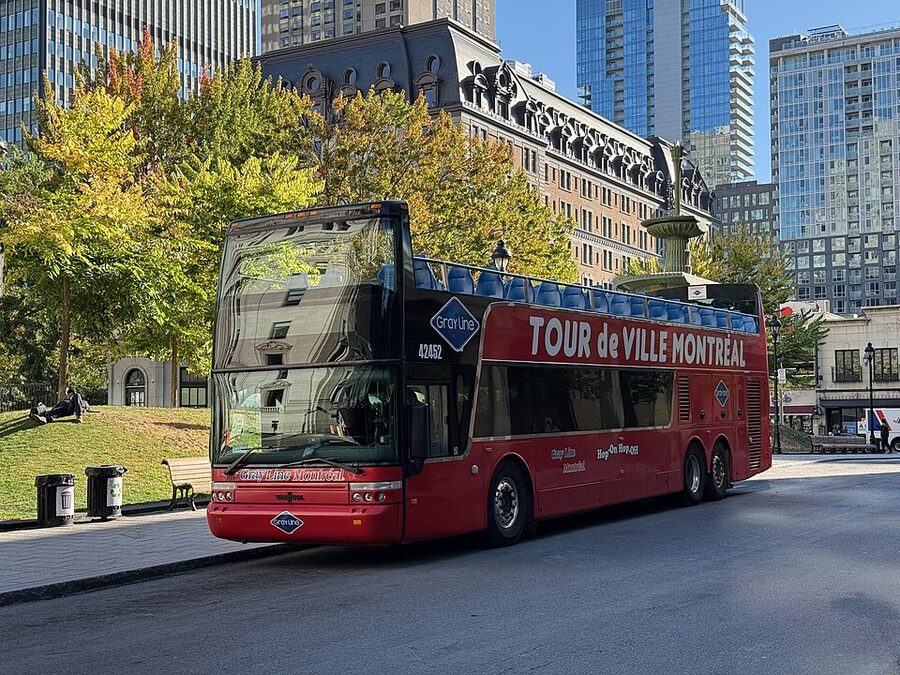Open-top Gray Line double-decker bus parked at Dorchester Square in Montreal