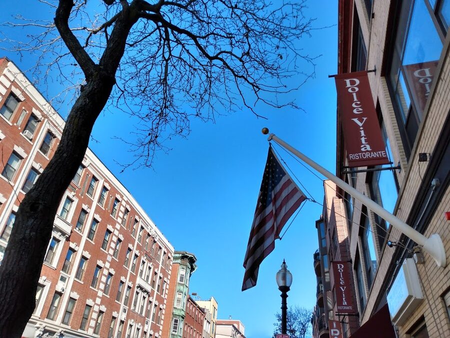 Hanover Street in Boston's North End with an American flag hanging over the road