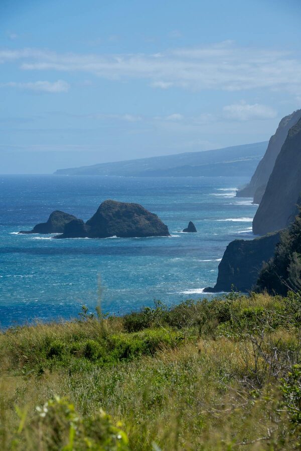 Hawaiian coastline with green cliffs and deep blue ocean