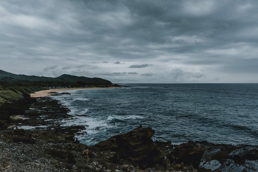 Dramatic Hawaiian coastline with storm clouds and rugged rocks
