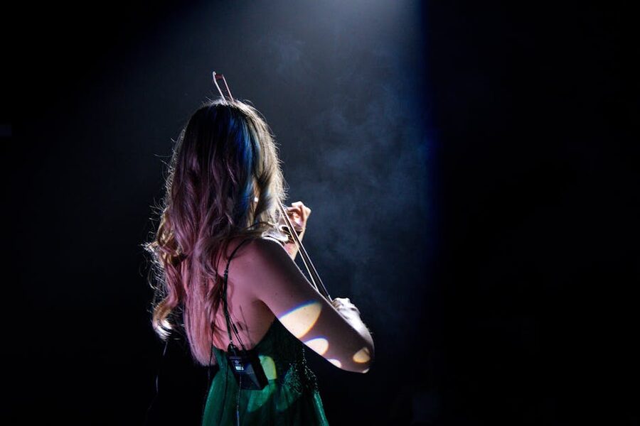 Violinist performing on stage under a spotlight