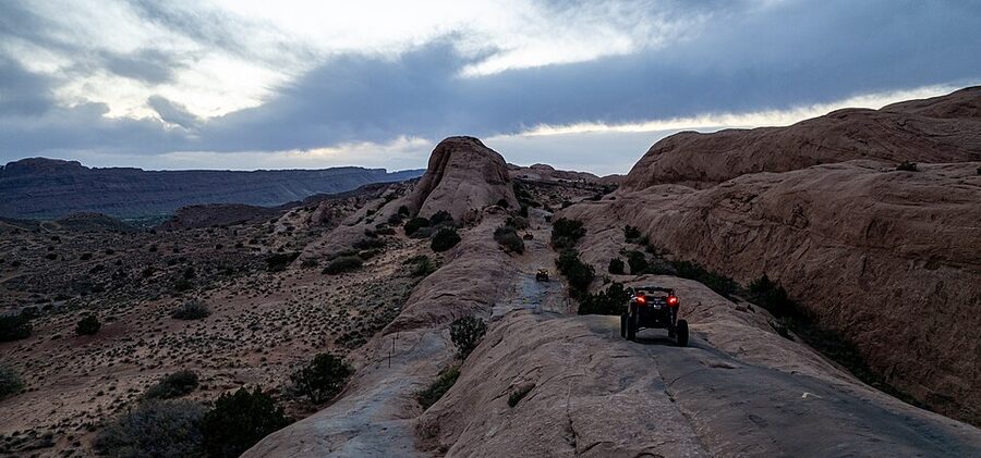 Three off-highway vehicles descending the entrance fin at Hell's Revenge near Moab