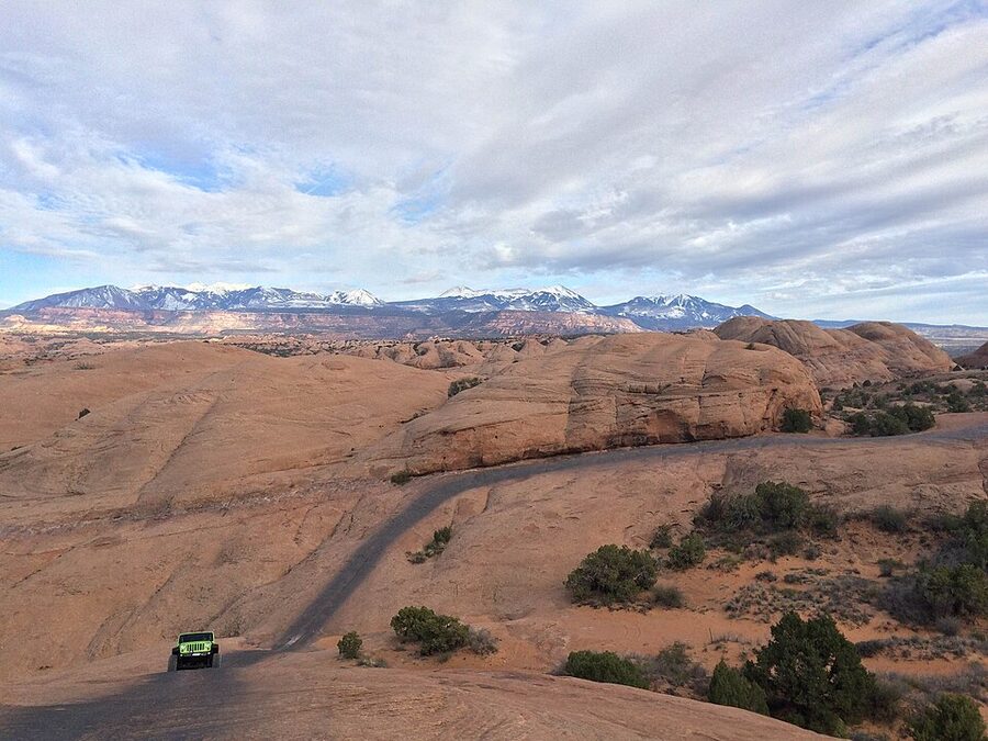 Jeeps climbing a steep slickrock fin on the Hell's Revenge trail Moab