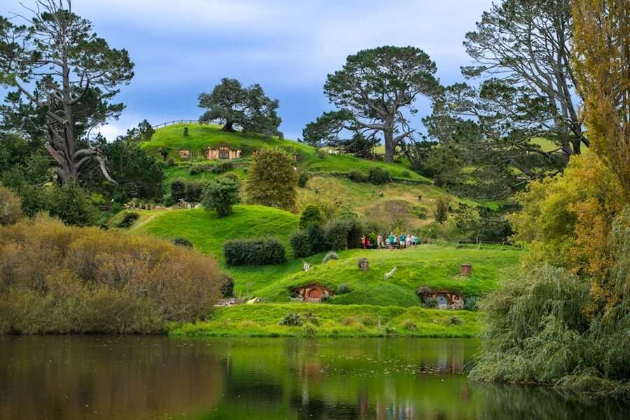 Hobbiton Movie Set hobbit holes and lake reflection