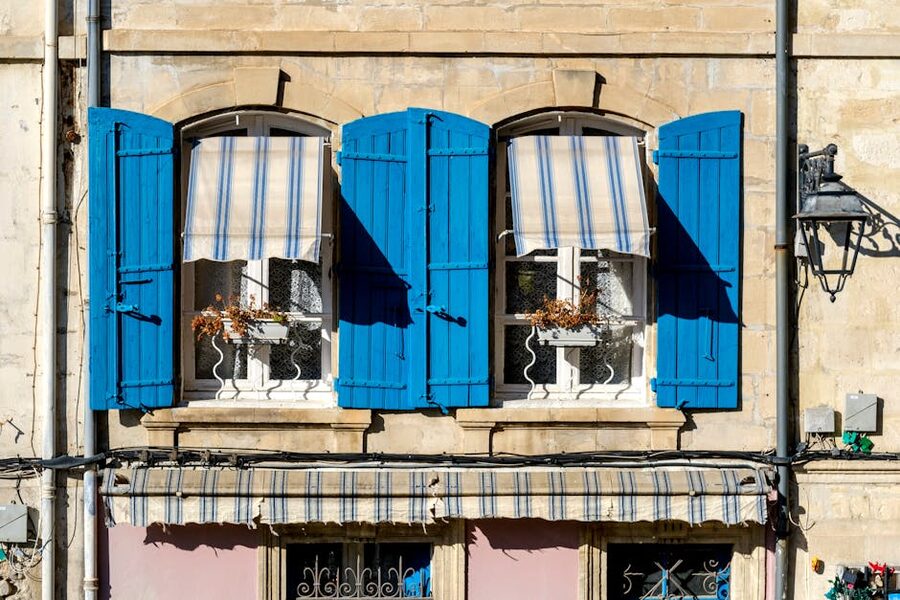 Provence blue shutters window striped awning Arles