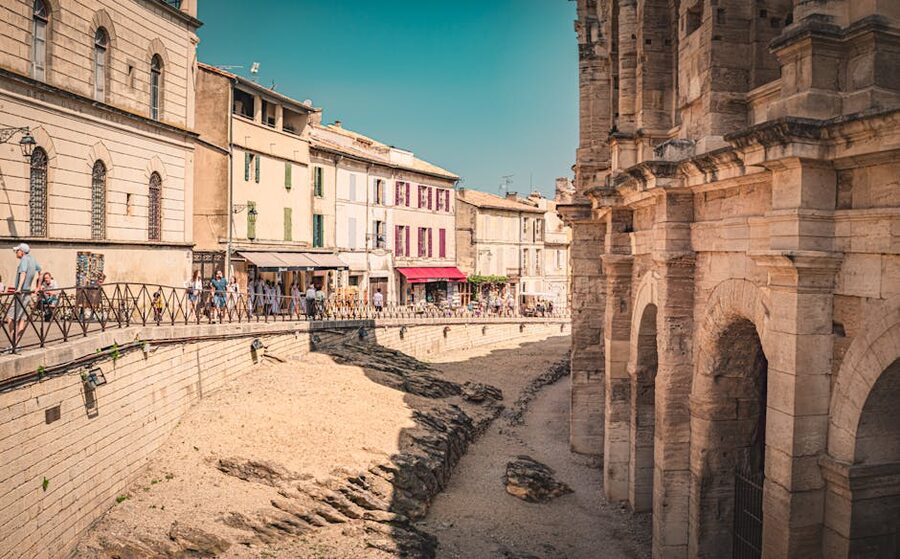 Arles summer street scene with awnings and historic architecture