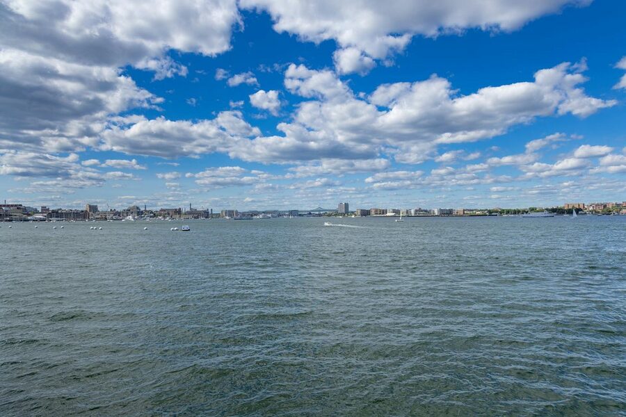 Boston harbor cityscape with scattered clouds