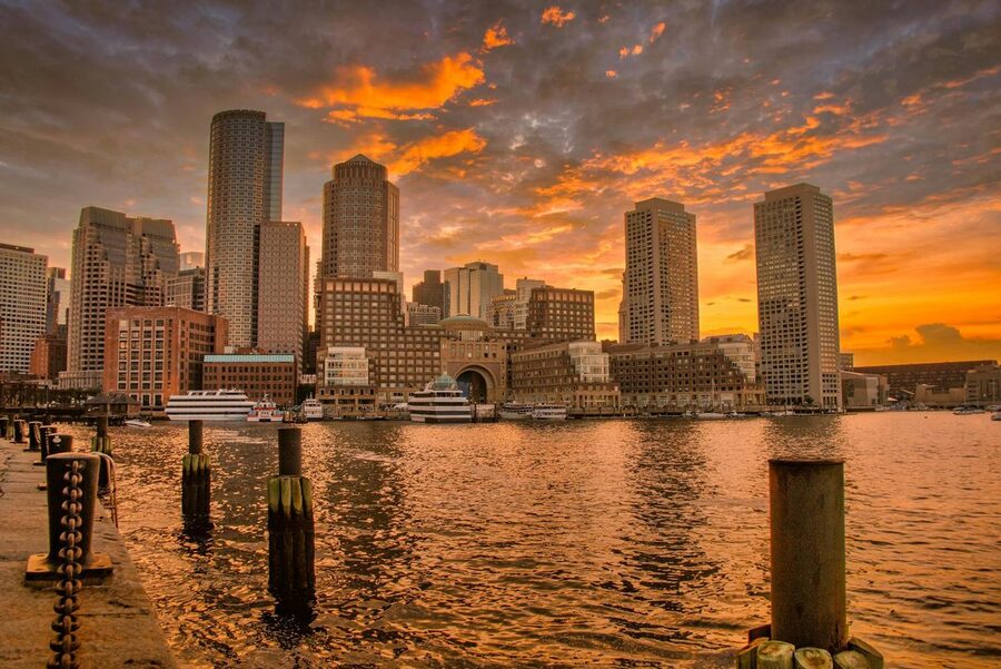 Boston skyscrapers at sunset reflected in the harbor