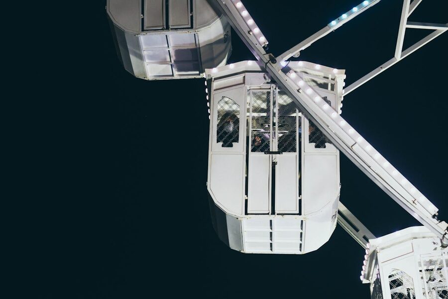 Ferris wheel cabin illuminated against the night sky