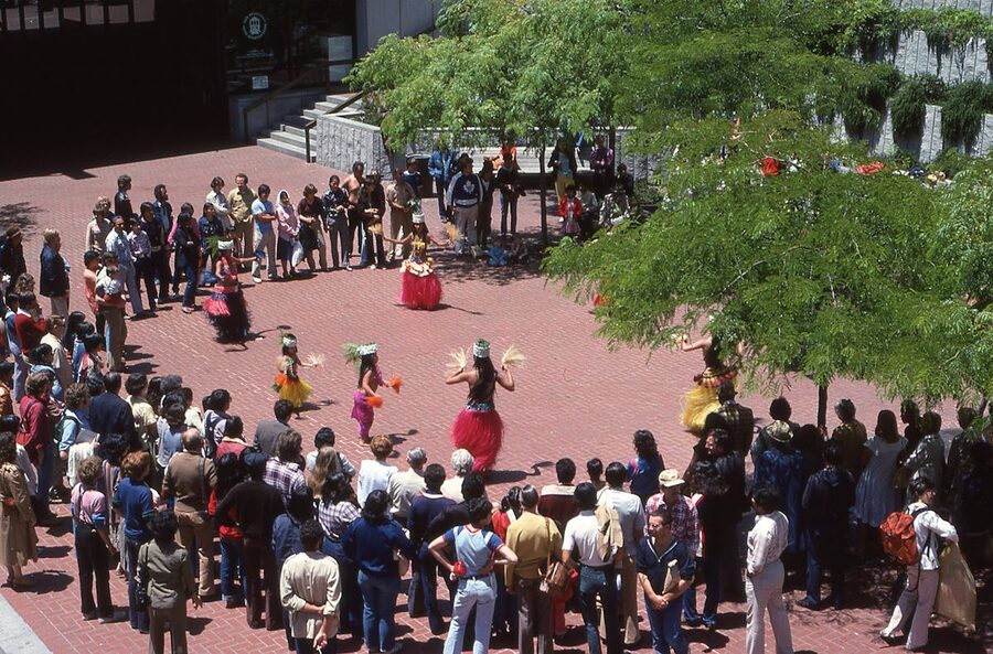 Aerial shot of hula dancers performing surrounded by a crowd outdoors in Hawaii