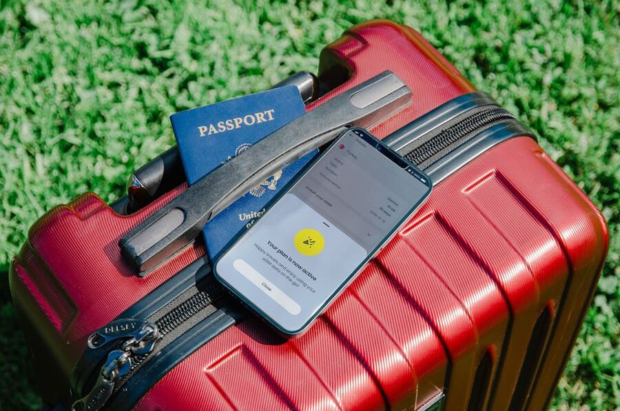 Traveller's mobile phone with ticket and passport on a suitcase