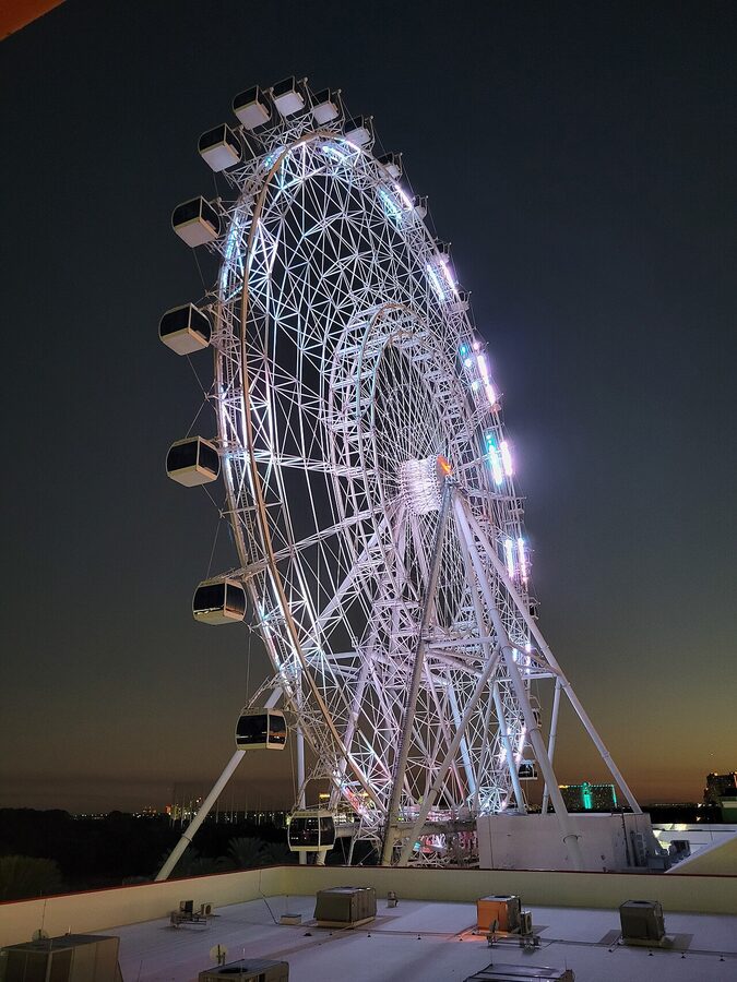 The Wheel at ICON Park in Orlando lit in purple against a night sky