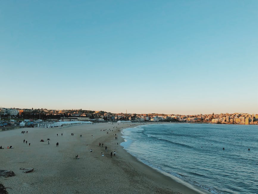 People walking on Bondi Beach at sunset