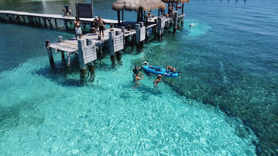 Isla Mujeres pier with swimmers in clear turquoise water