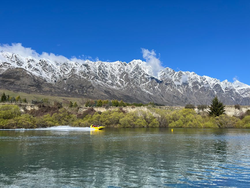 Yellow jet boat speeding across Lake Wakatipu under the Remarkables