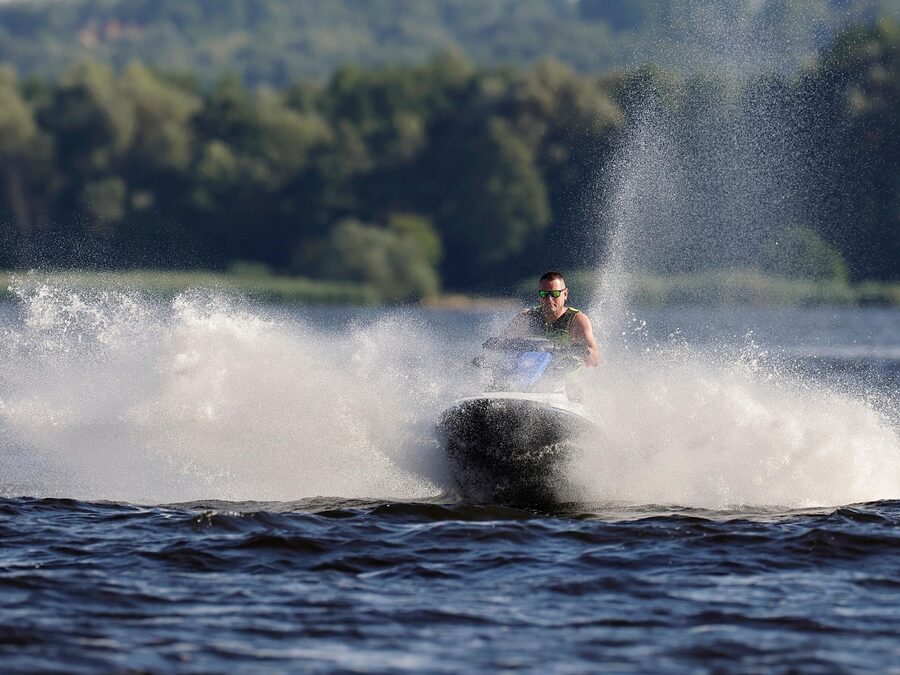 Jet ski rider with spray crossing coastline