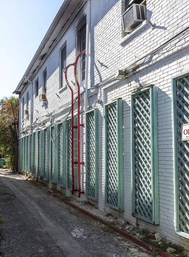 Narrow alley with wooden fences and tropical plants in the Key West Historic District