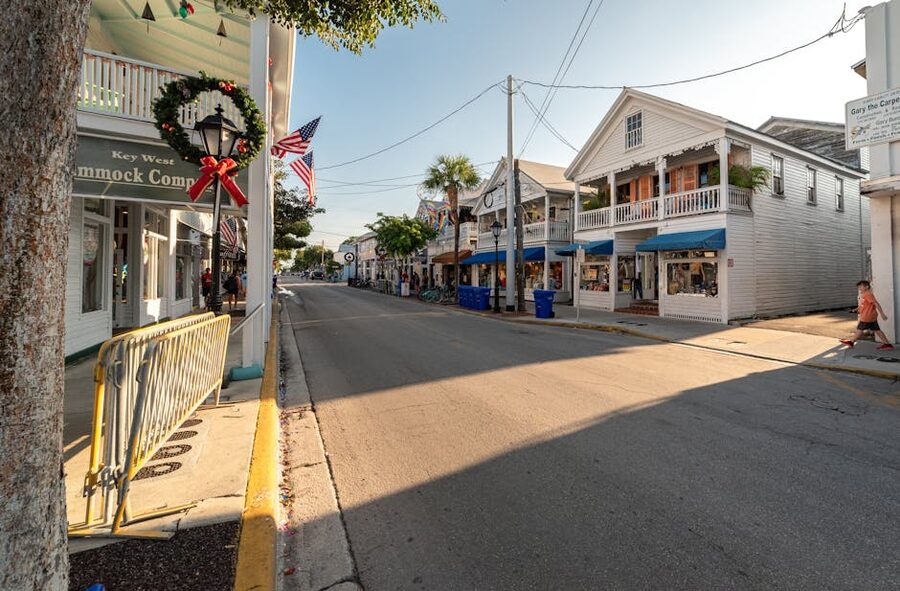 Sunny Old Town Key West street with American flags and palm trees