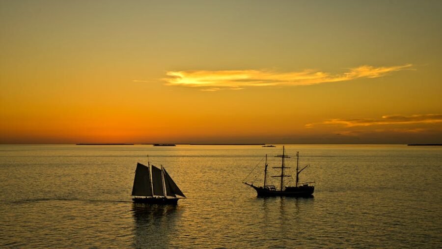 Sailing ships against a warm Key West sunset skyline
