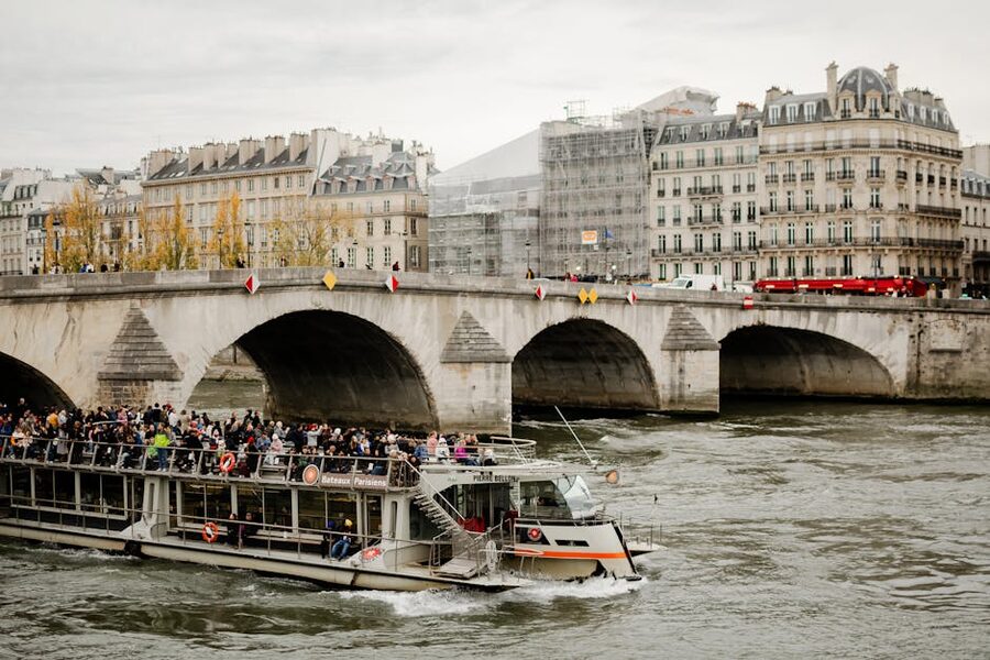 Seine River tour boat passing under a bridge in central Paris