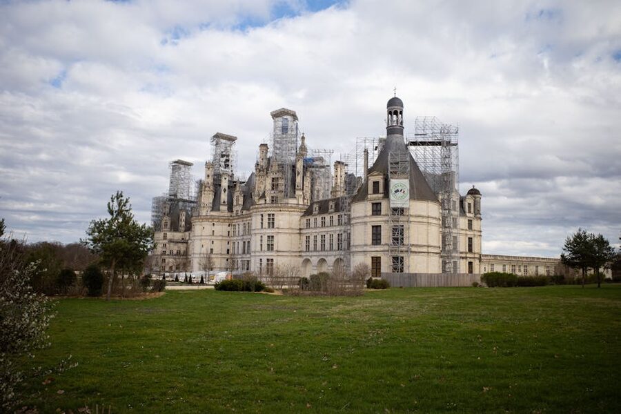 Chateau de Chambord under wide clouds and green lawns
