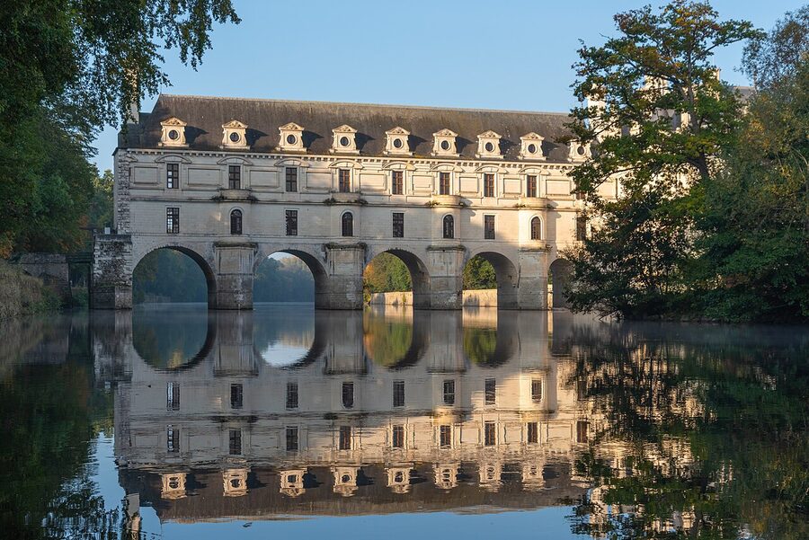 Chenonceau east facade reflected in the Cher river at morning