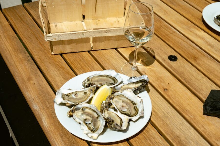 Plate of oysters with white wine glass and lemon