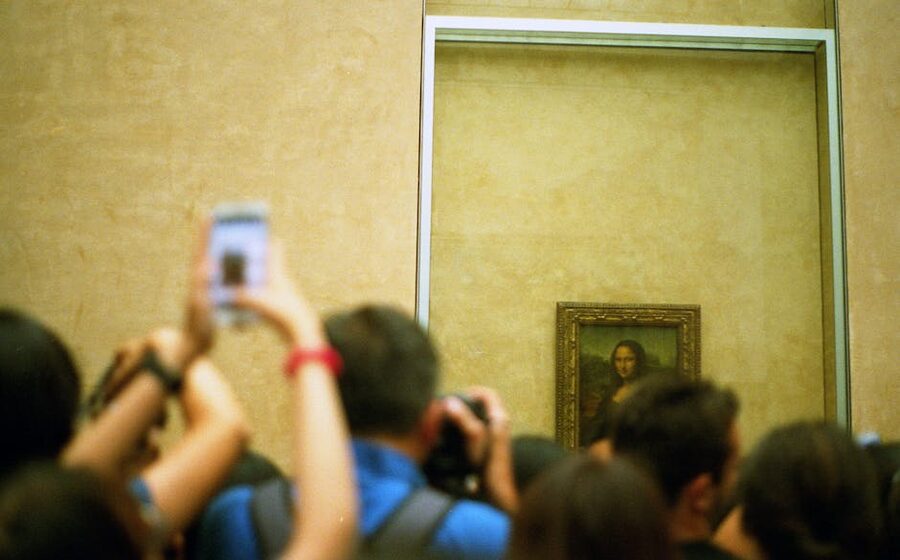 Visitors photographing the Mona Lisa at the Louvre
