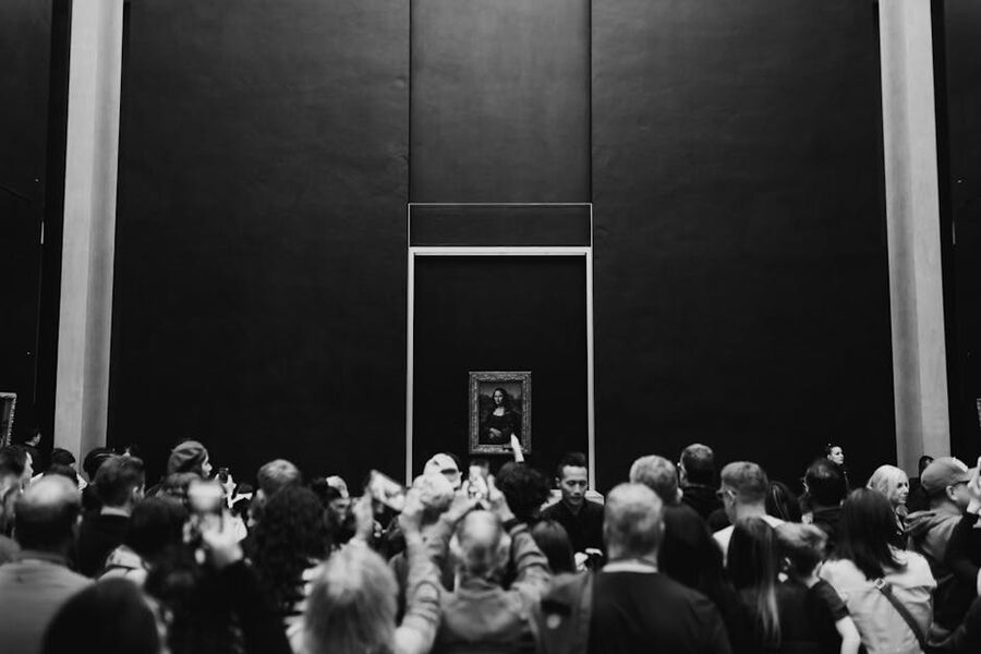 A large crowd gathers in front of the Mona Lisa at the Louvre