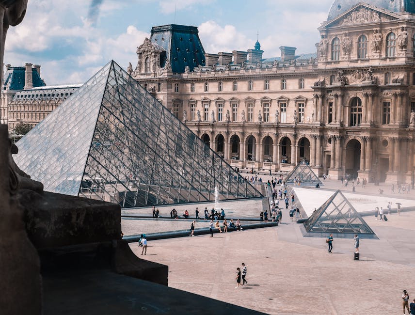 The Louvre Museum and glass pyramid in Paris on a bright day