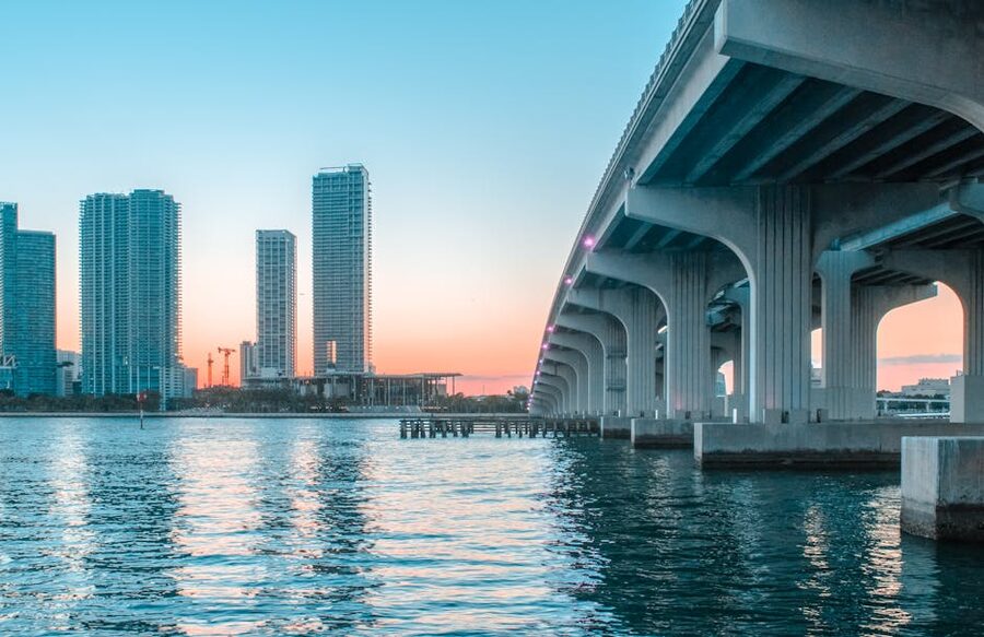 Miami Beach skyline across a causeway bridge at sunset