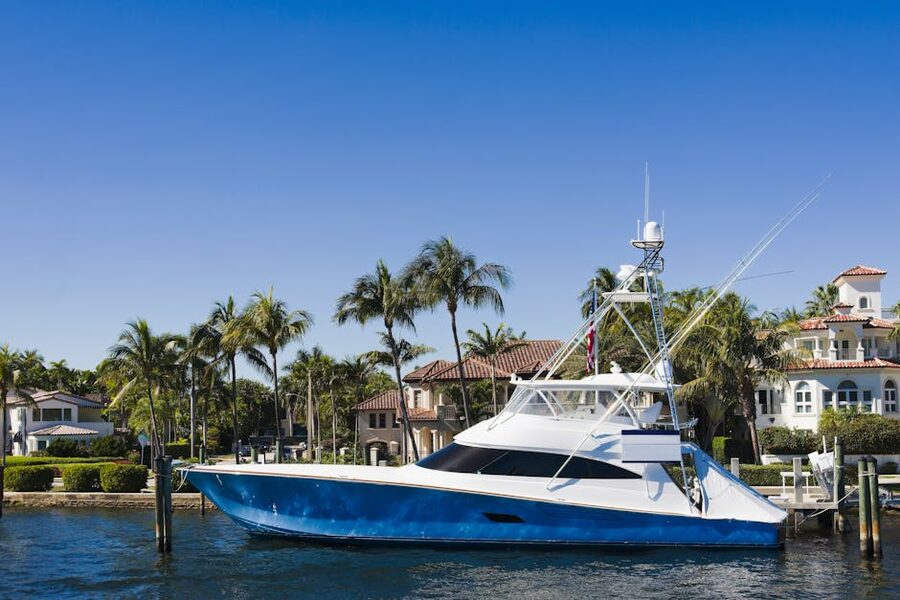 Blue and white motor yacht on Biscayne Bay with palm trees and waterfront mansions