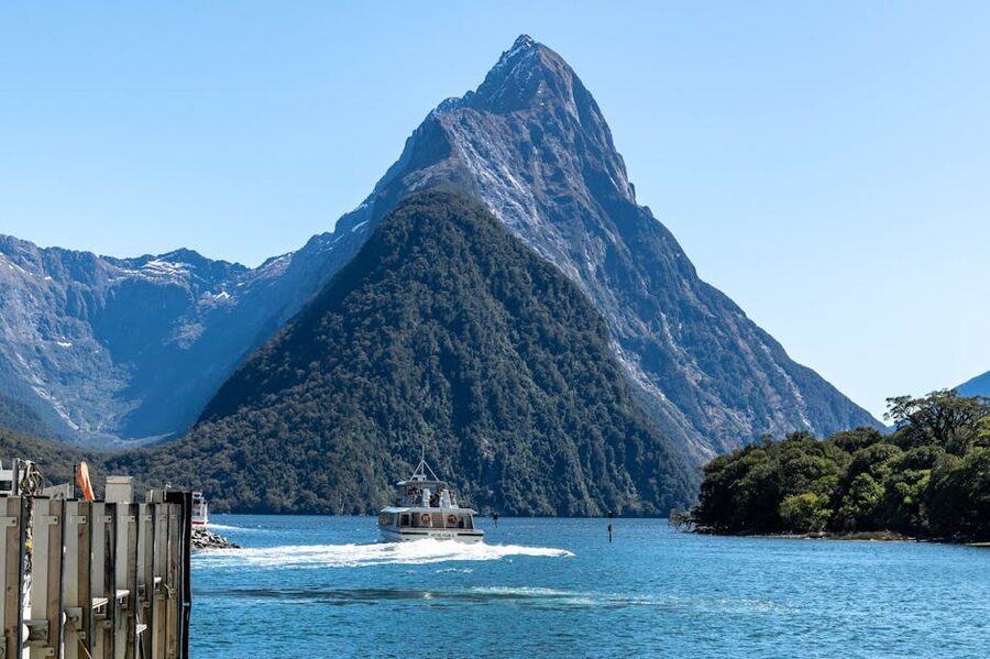 Cruise boat below cliffs in Milford Sound